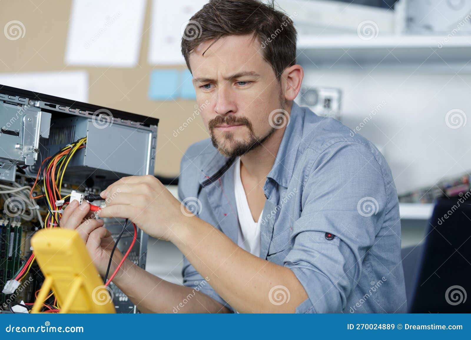 Technician Using Voltage Meter for Voltage Measurement in Computer ...