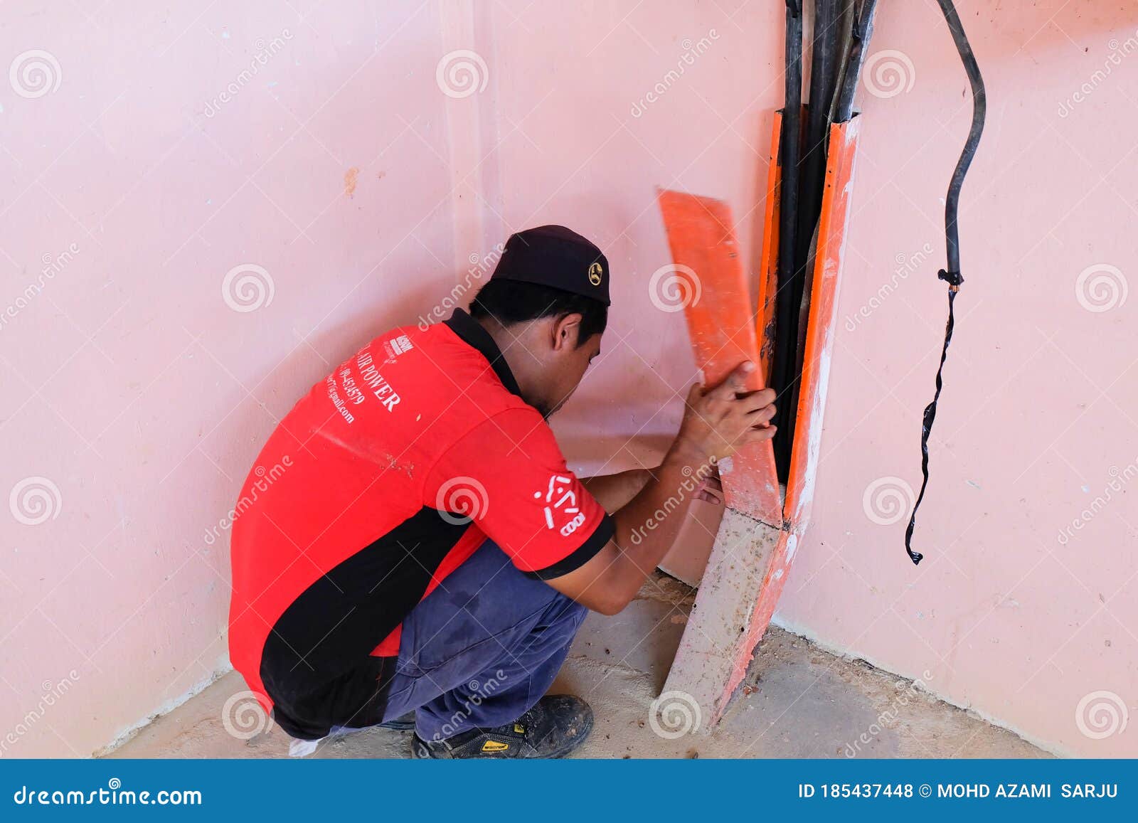 Technician Wiring Cable in Front of Electrical Panel for Control and ...