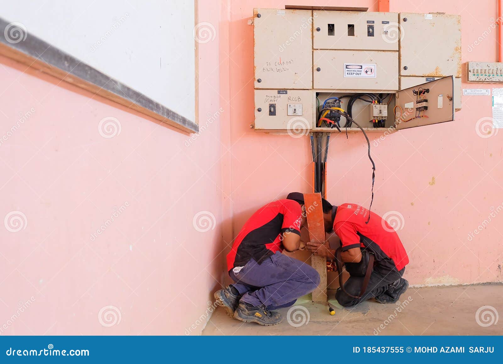 Technician Wiring Cable in Front of Electrical Panel for Control and ...