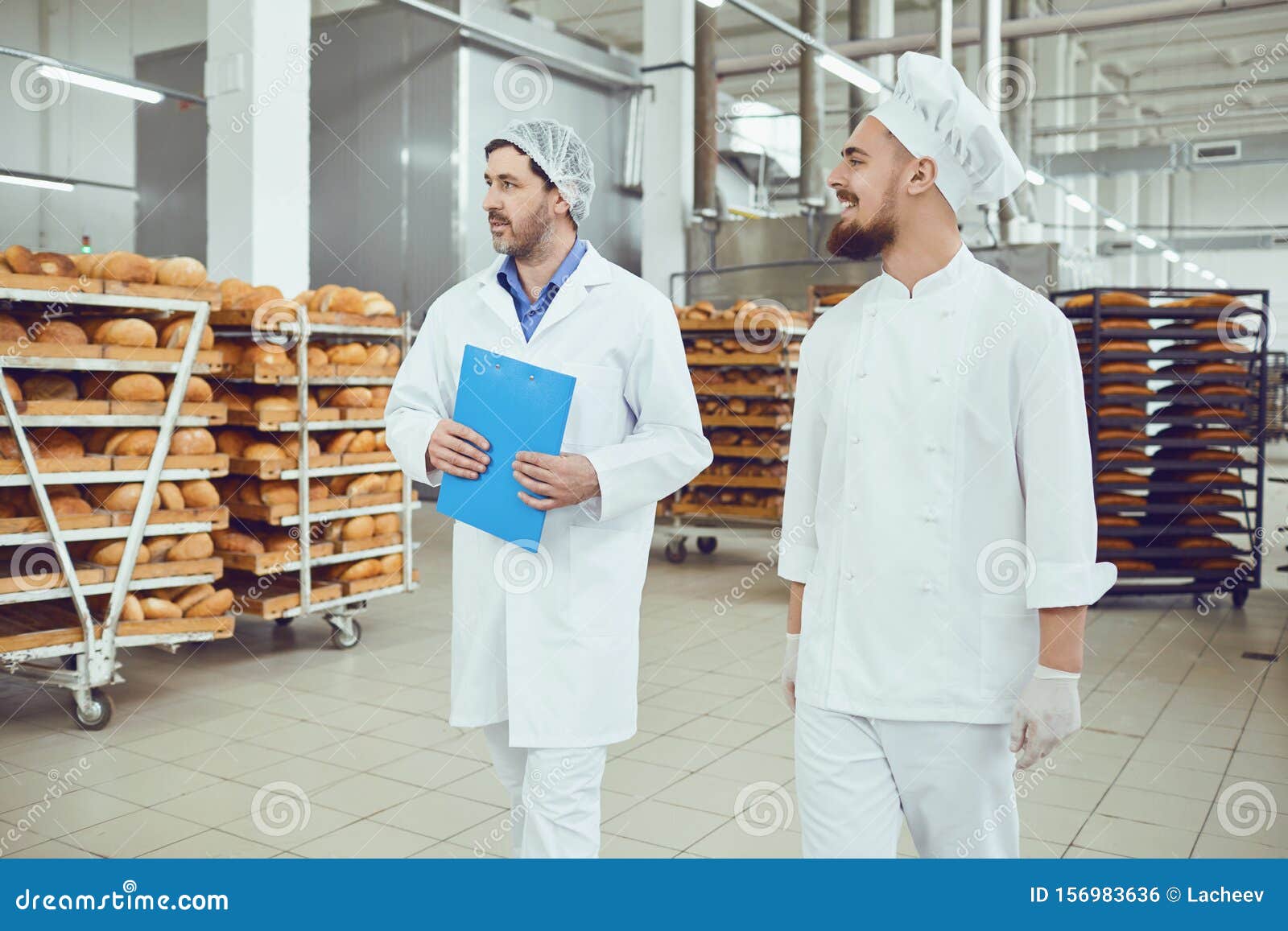 The Technologist and Baker Speak in a Bread Factory. Stock Photo ...