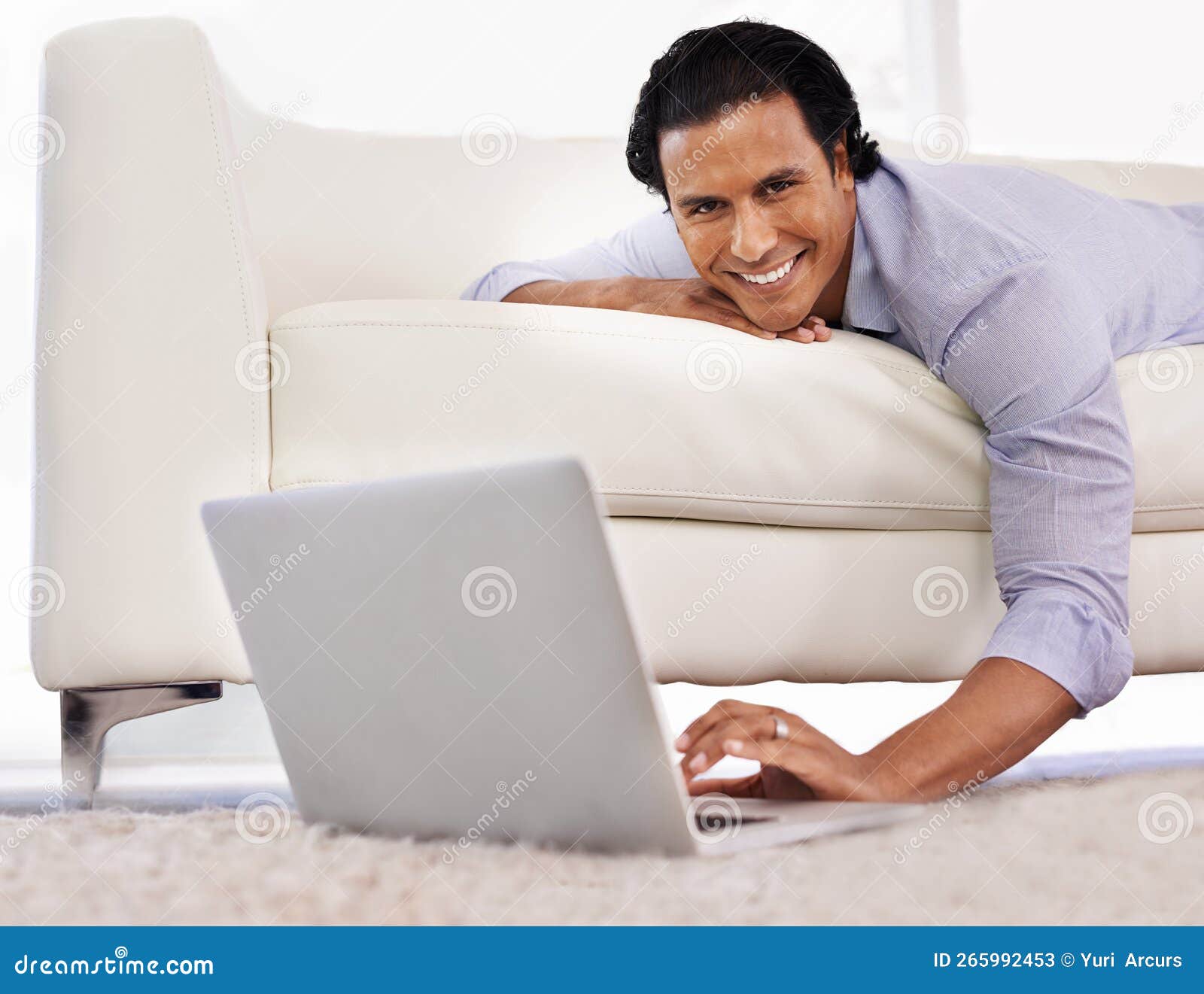 Technology at Home. a Handsome Young Man Using His Laptop at Home ...