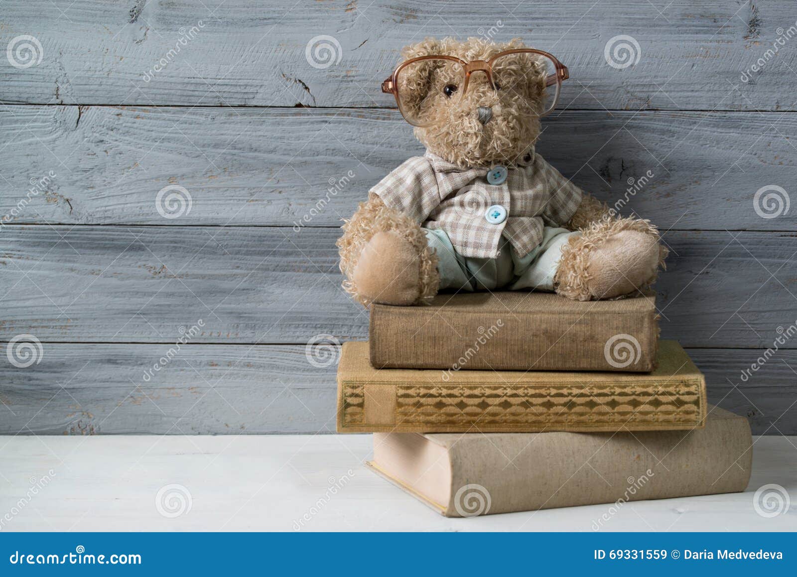 Teddy Bear in Reading Glasses Sitting on the Stack of Old Books Stock ...