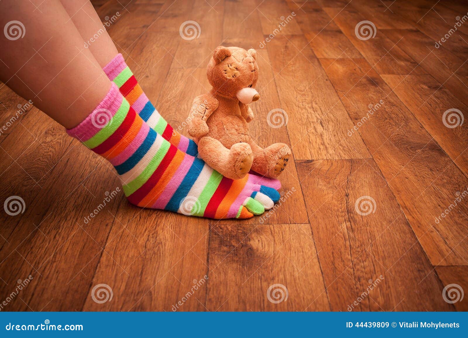 Teddy bear sits on legs stock image. Image of floor, socks - 44439809