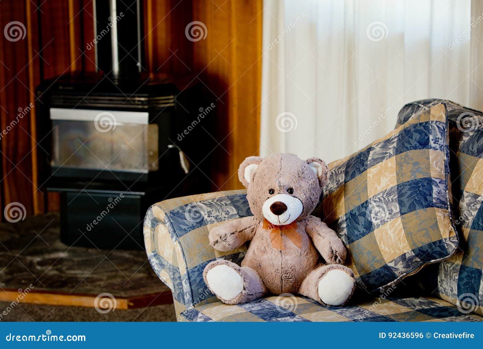Teddy Bear - Sitting on Sofa Couch in Front of Fireplace Stock Photo ...