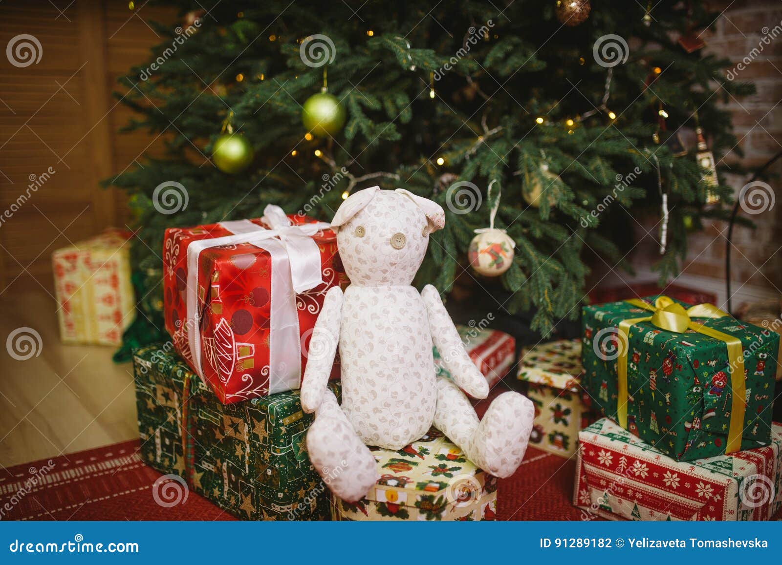 Teddy Bear Sitting Under Decorated with Lights Christmas Tree with Gift ...