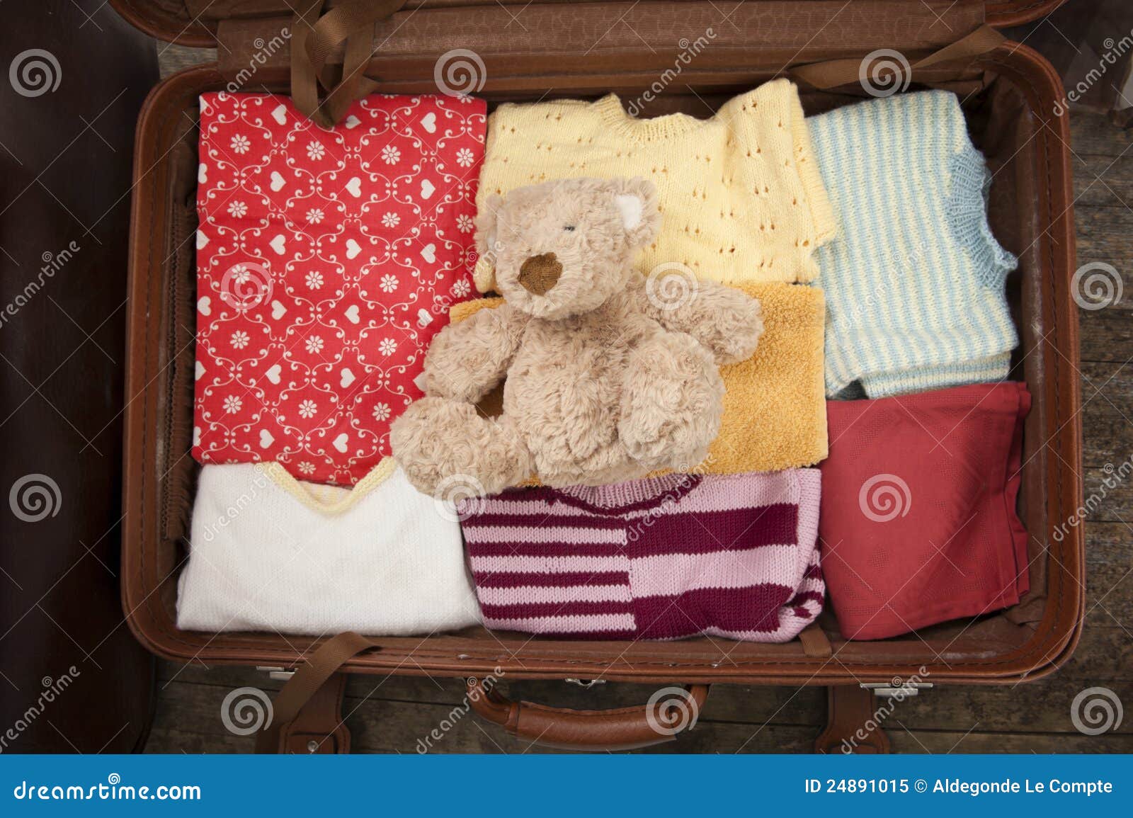 Open Suitcase On The Green Grass With Different Clothes Folded ...