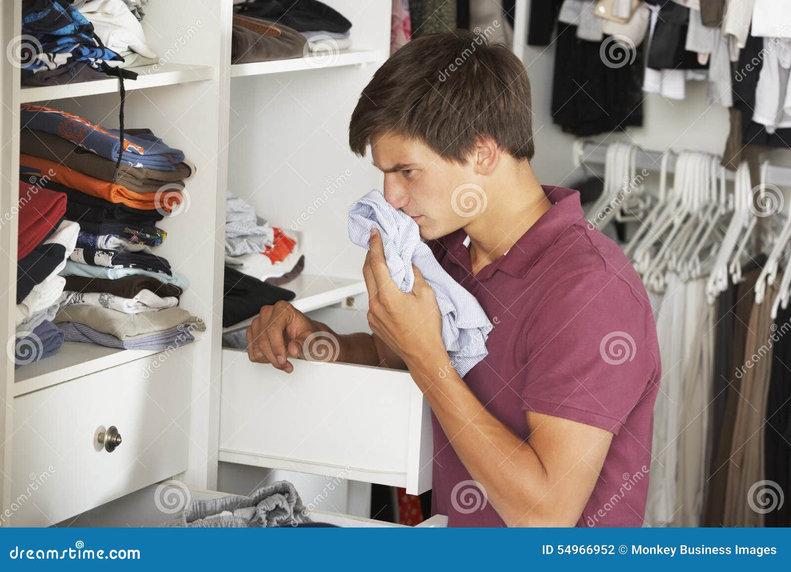 Teenage Boy Checking Freshness of Clothes in Wardrobe Stock Photo ...