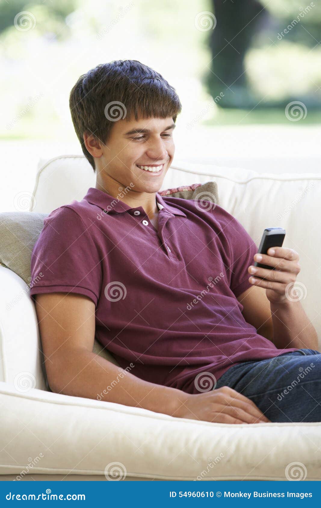 Teenage Boy Sending Text Message Sitting on Sofa Stock Photo - Image of ...