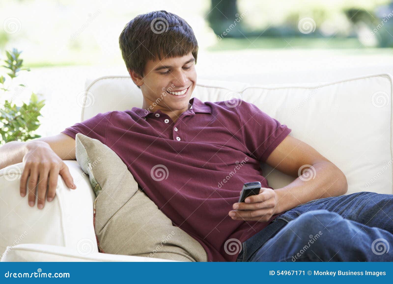 Teenage Boy Sending Text Message Sitting on Sofa Stock Image - Image of ...