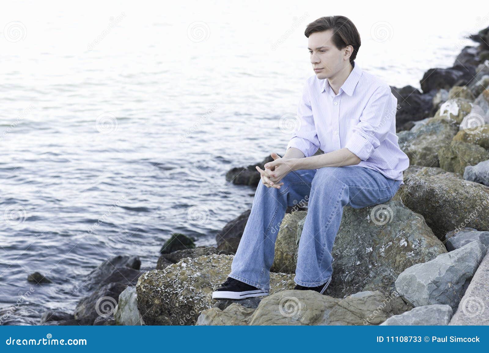 Teenage Boy Sitting on Rocks by Ocean Stock Image - Image of peace ...