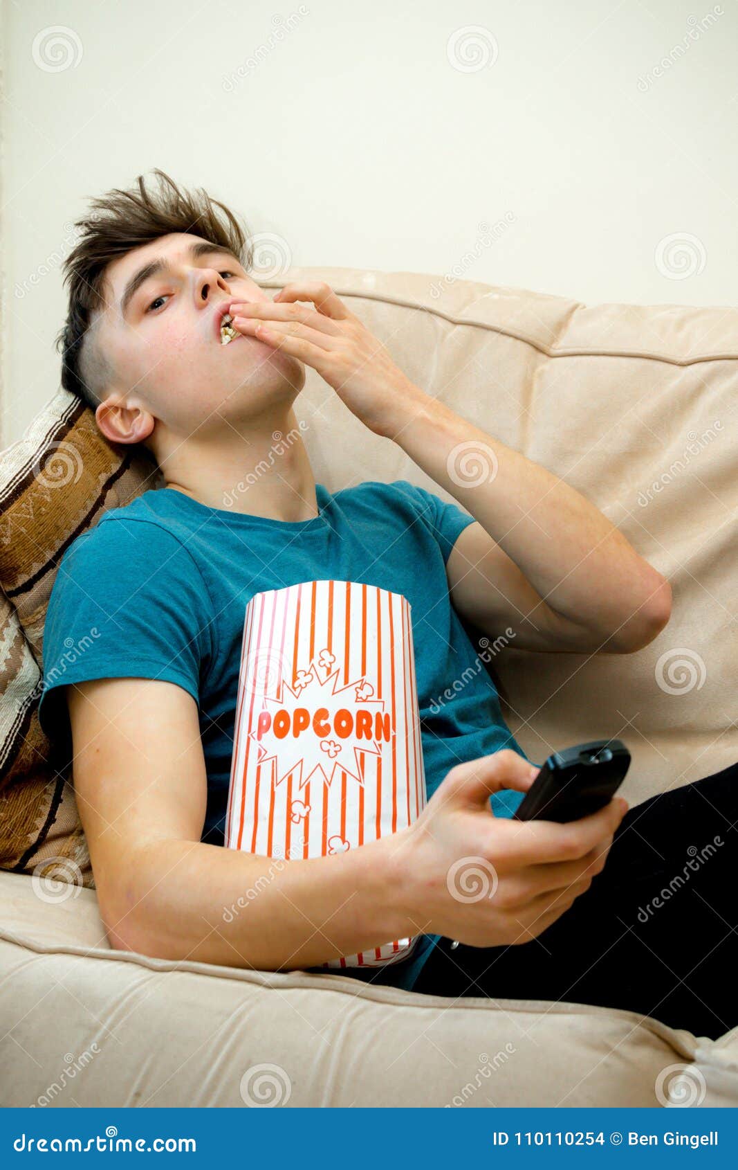 Teenage boy eating popcorn stock photo. Image of high - 110110254