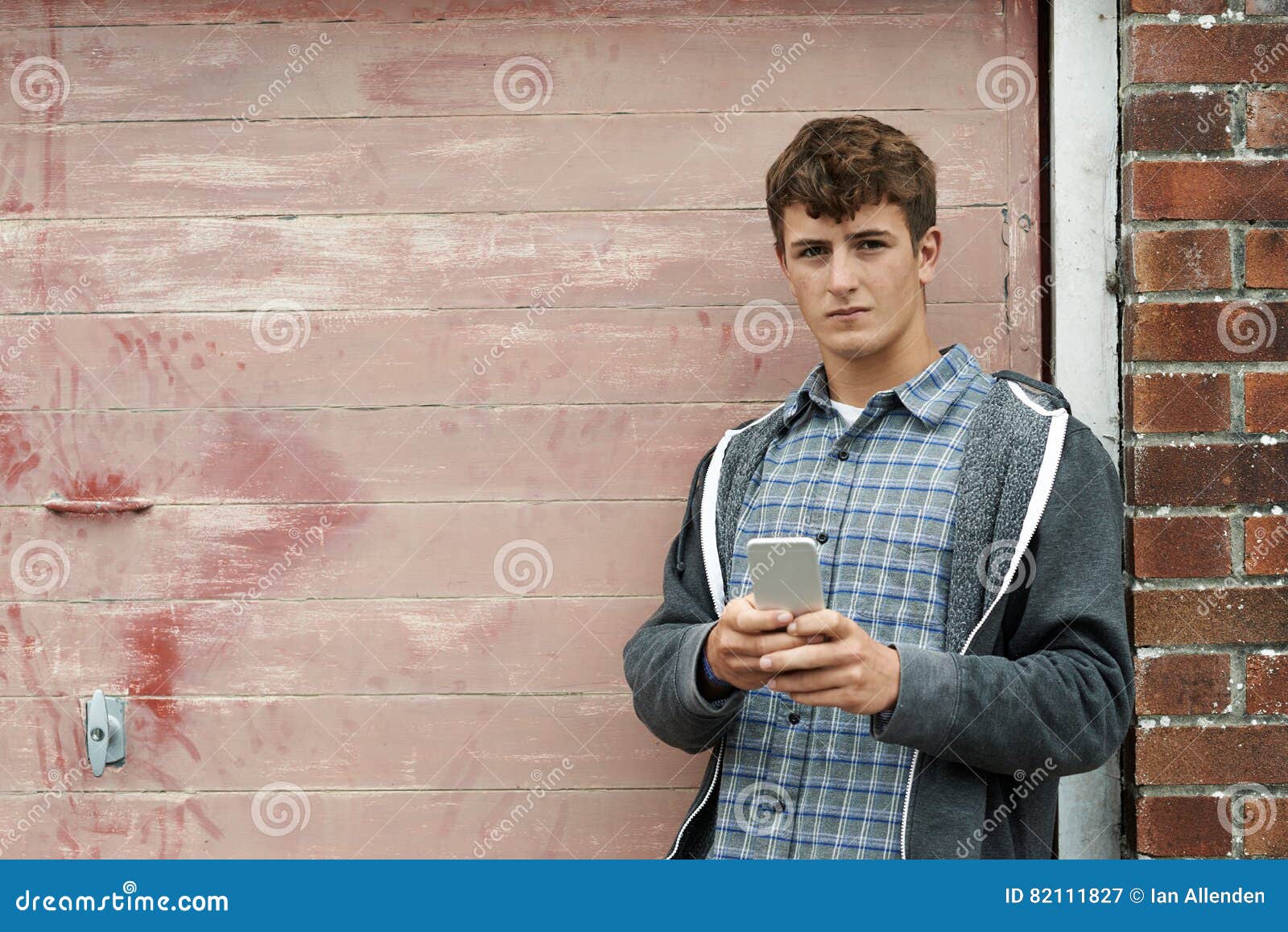 Teenage Boy Texting on Mobile Phone in Urban Setting Stock Image ...