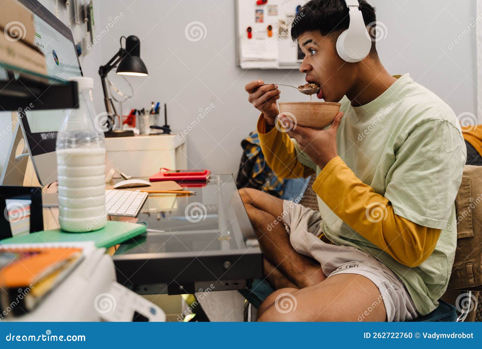 Teenage Boy Using Desktop Computer while Eating Breakfast in Bedroom ...