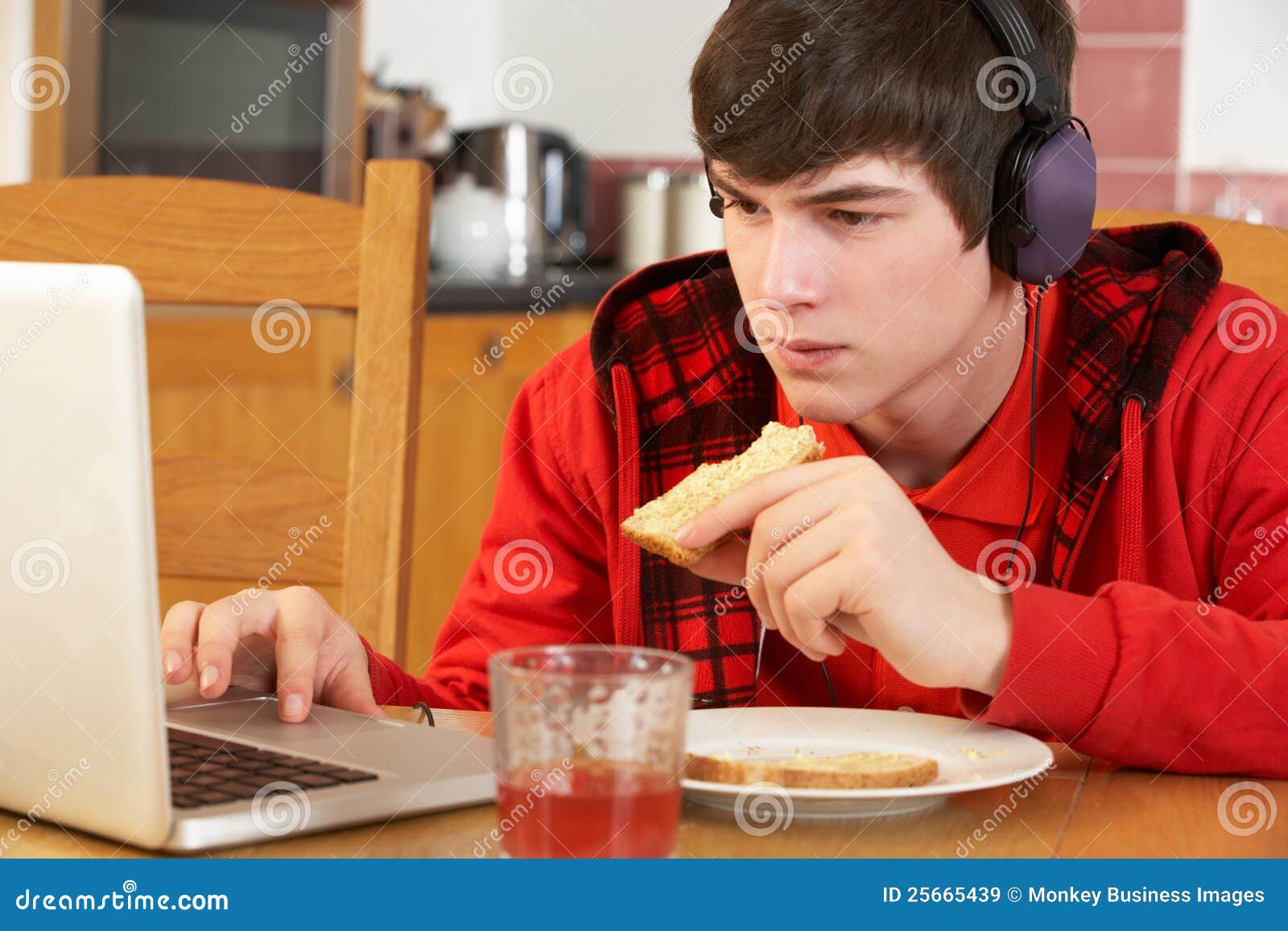 Teenage Boy Using Laptop Whilst Eating Breakfast Stock Image - Image of ...