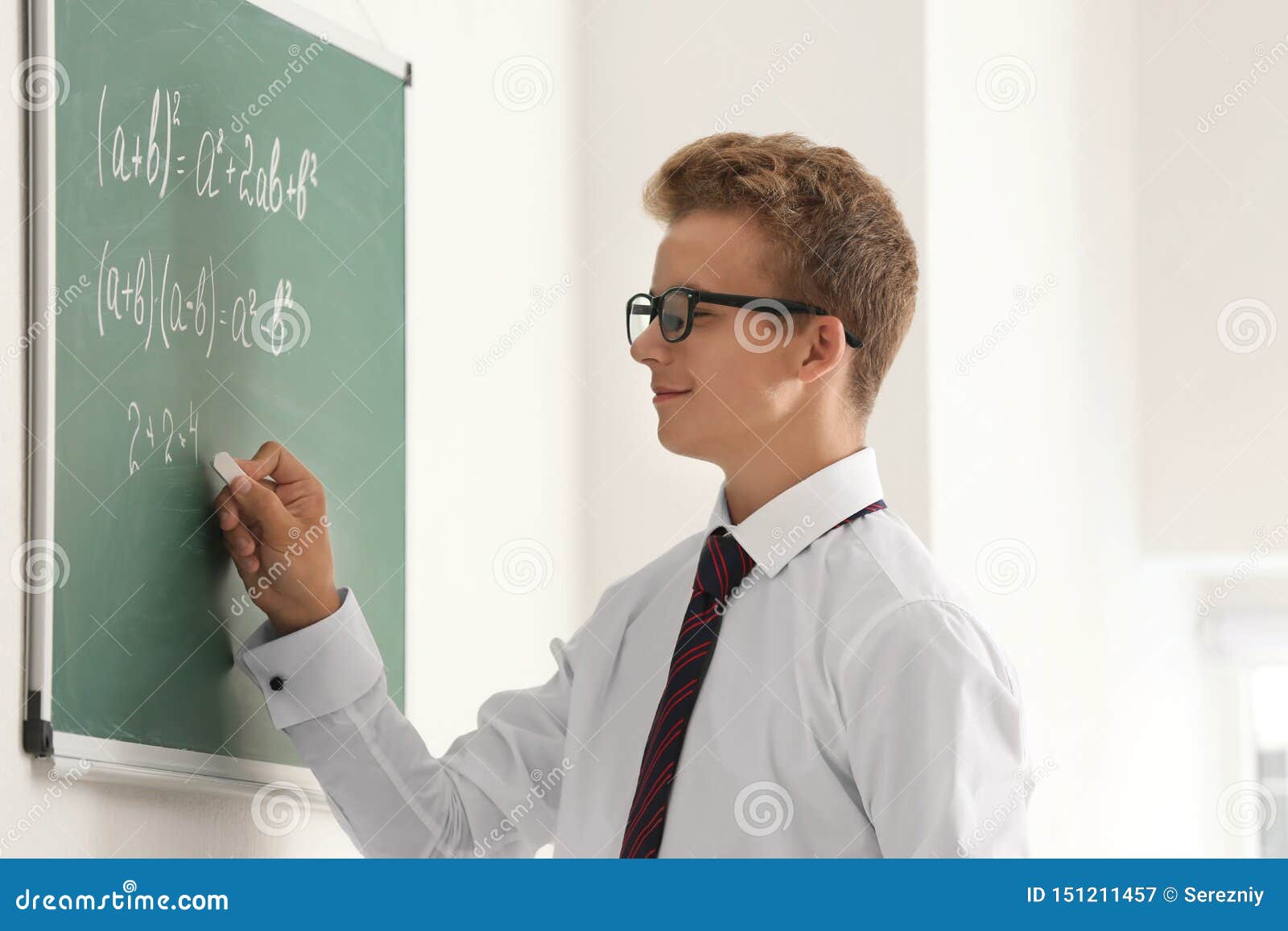 Teenage Boy Writing on Chalkboard in Classroom Stock Image - Image of ...