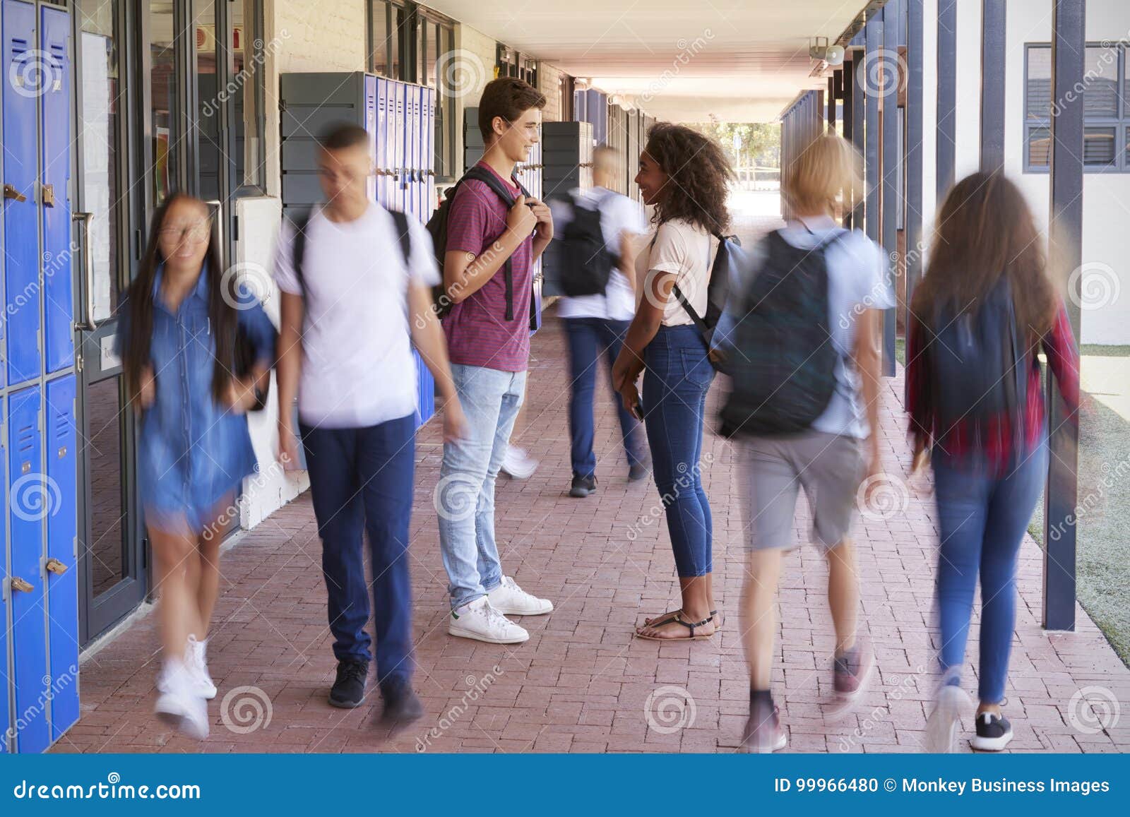 Teenage Classmates Stand Talking In School Hallway Stock Photo ...