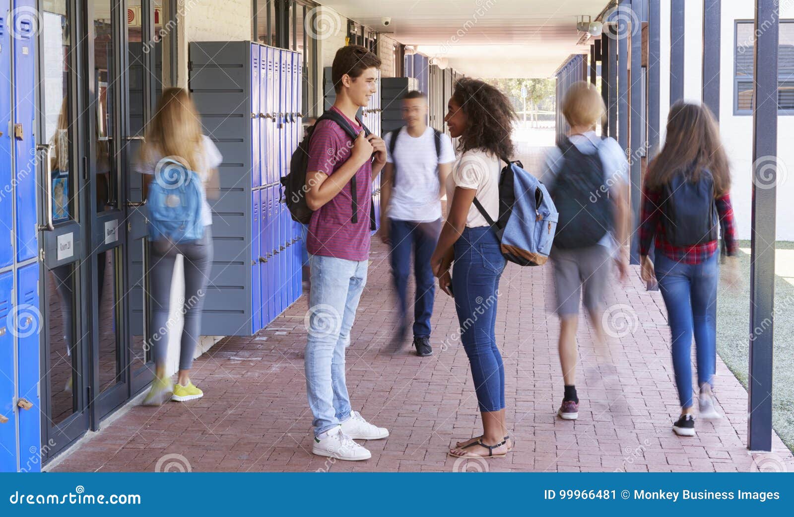 Teenage Classmates Stand Talking in School Hallway Stock Image - Image ...