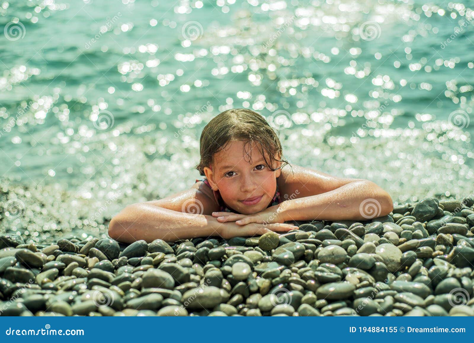 Teenage Girl Lying on a Pebble Beach with Turquoise Sea on the ... Teenage Girl Lying on a Pebble Beach with Turquoise Sea on the ...