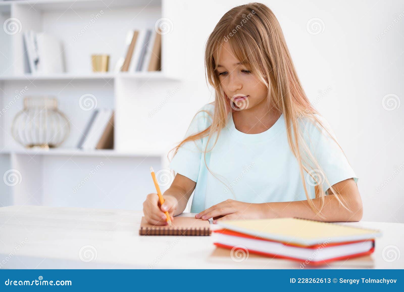 Teenage Girl Making Notes in Notepad, Doing Homework at Table at Home ...