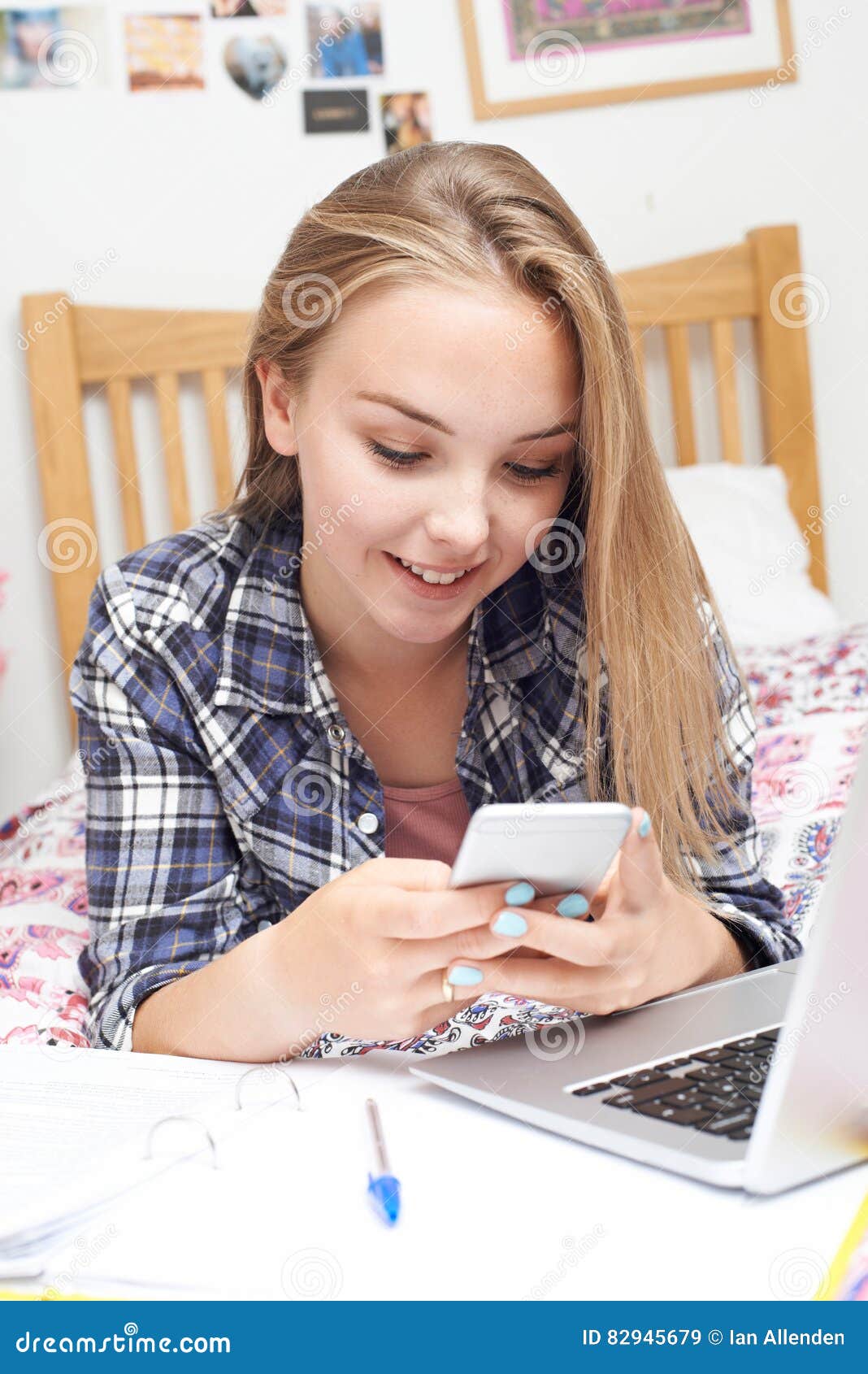 Teenage Girl Using Mobile Phone Whilst Doing Homework Stock Image ...