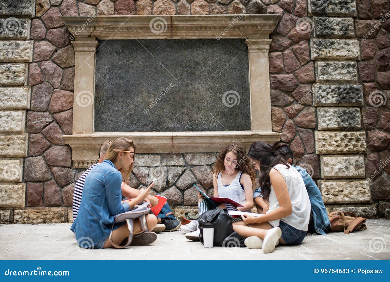 Teenage Students Sitting on the Ground in Front of University. Stock ...