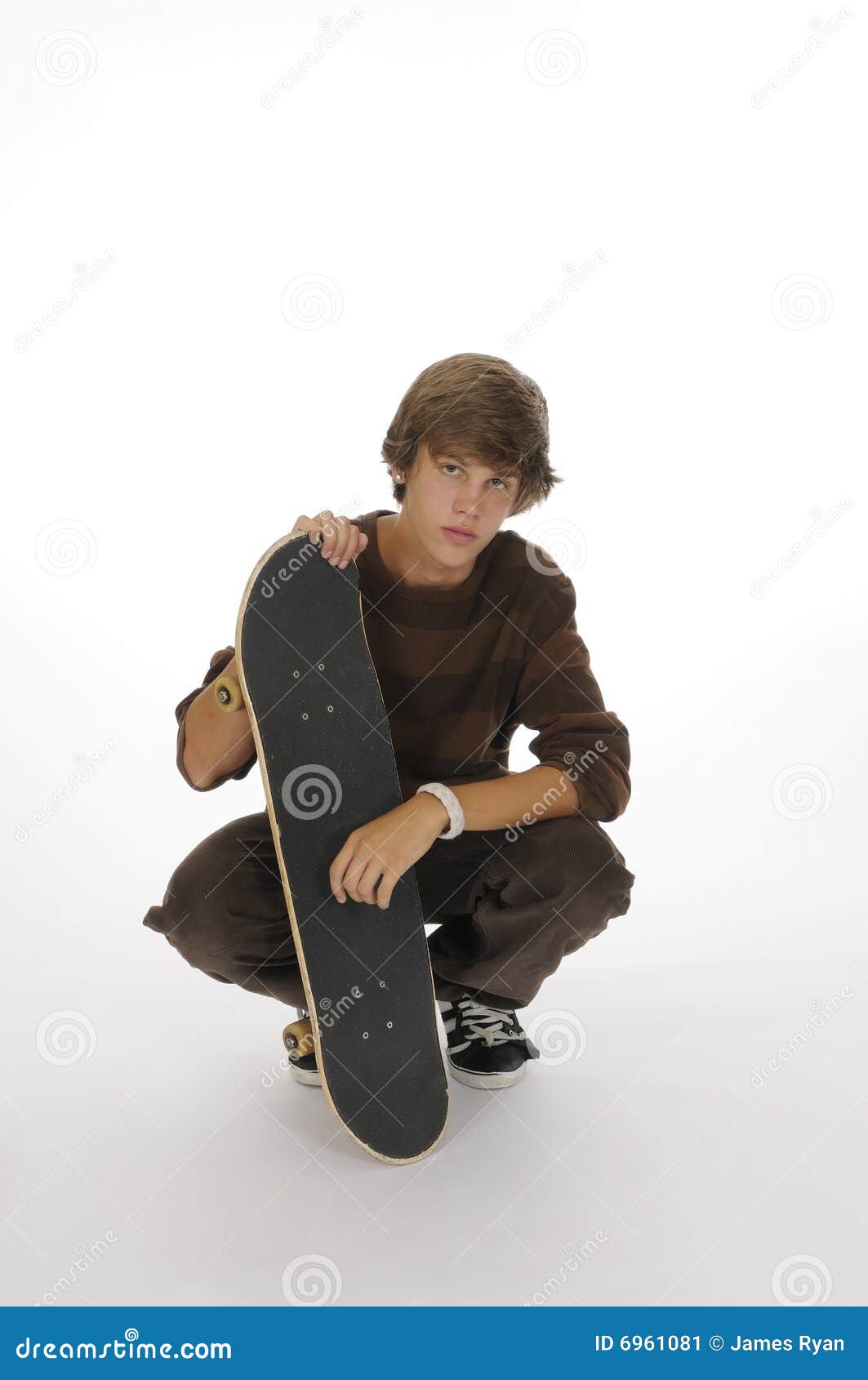 Teenager Crouched Holding Skateboard Stock Image - Image: 6961081 Teenager Crouched Holding Skateboard Stock Image - Image: 6961081