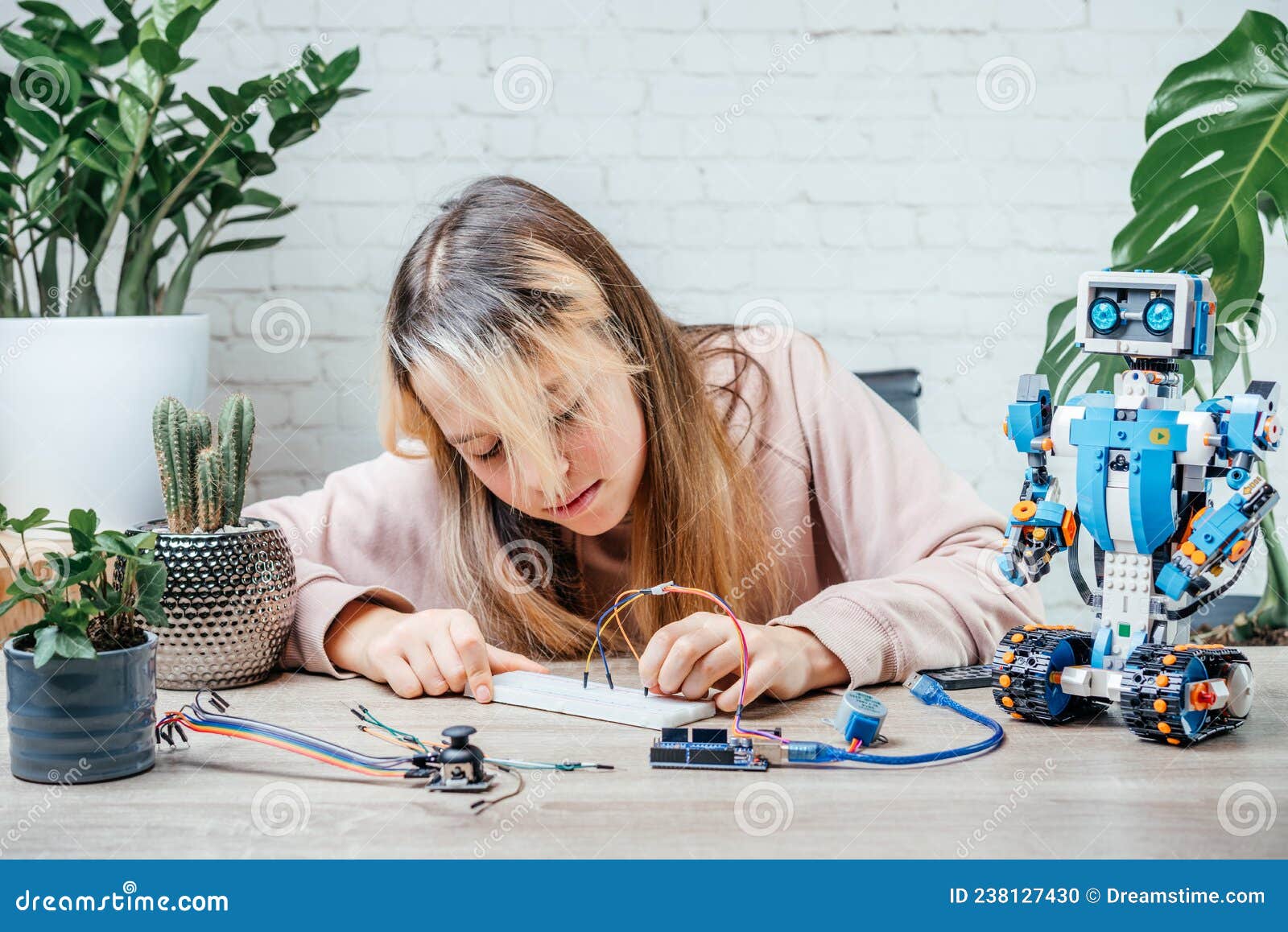 A Teenager Girl Plugging Cables To Sensor Chips while Learning Arduino ...