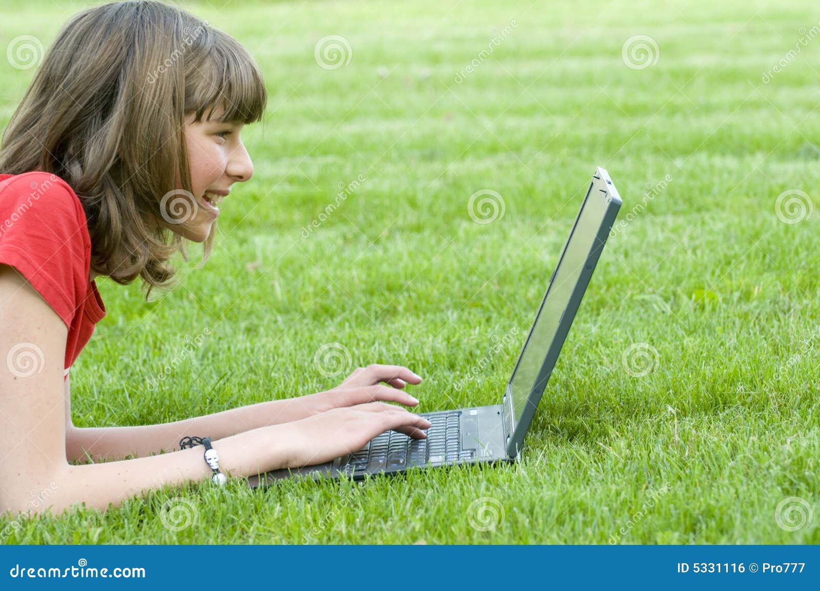 Teenager Typing on Computer on the Grass Stock Photo - Image of field ...