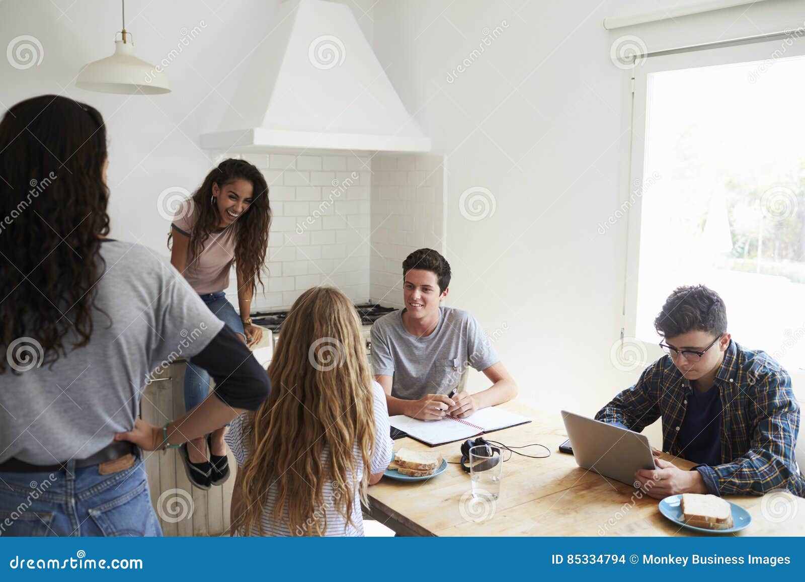 Teens Hanging Out in Kitchen, Doing Homework and Talking Stock Photo ...