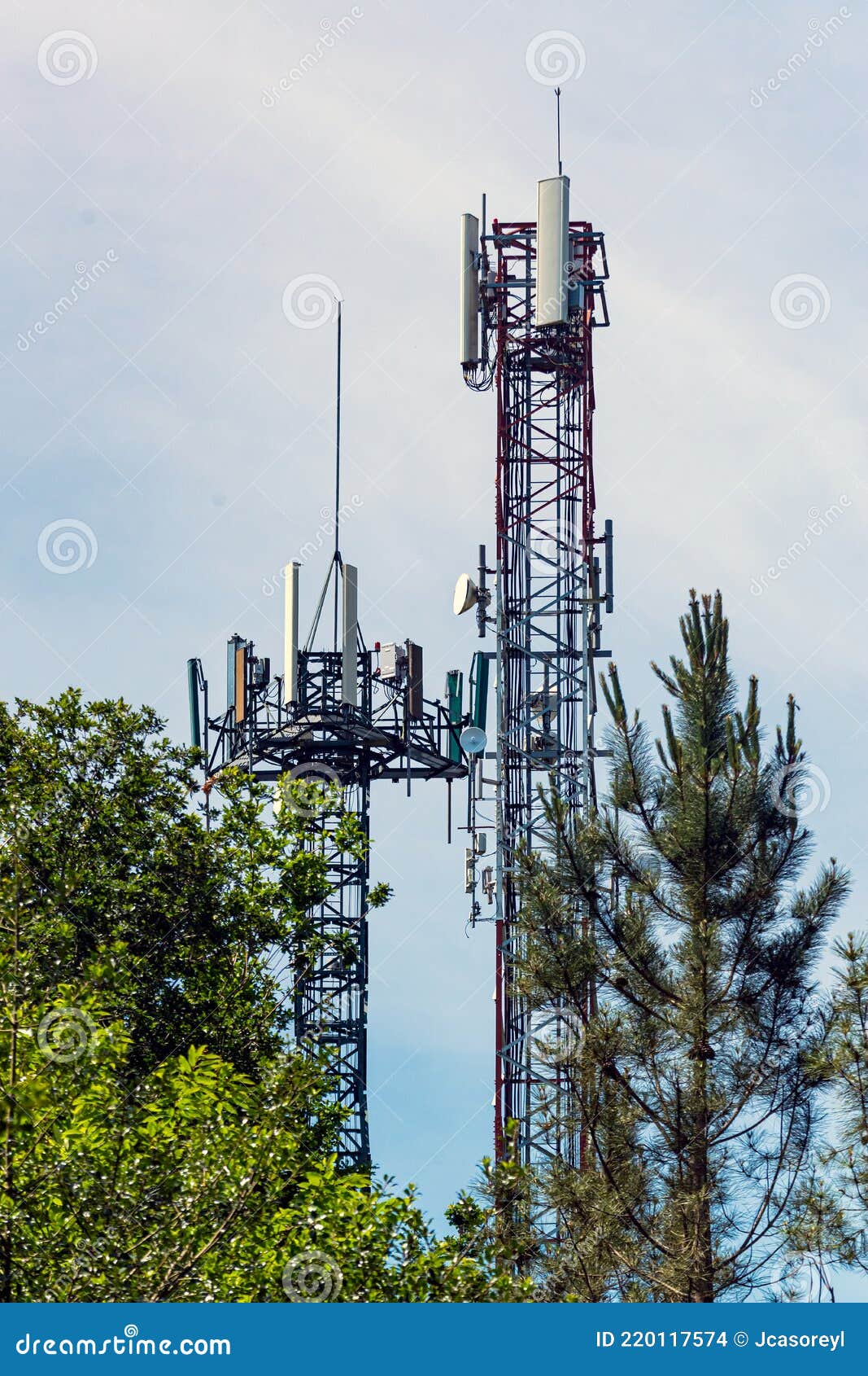 Telecommunications Towers between Trees and the Sky in the Background ...