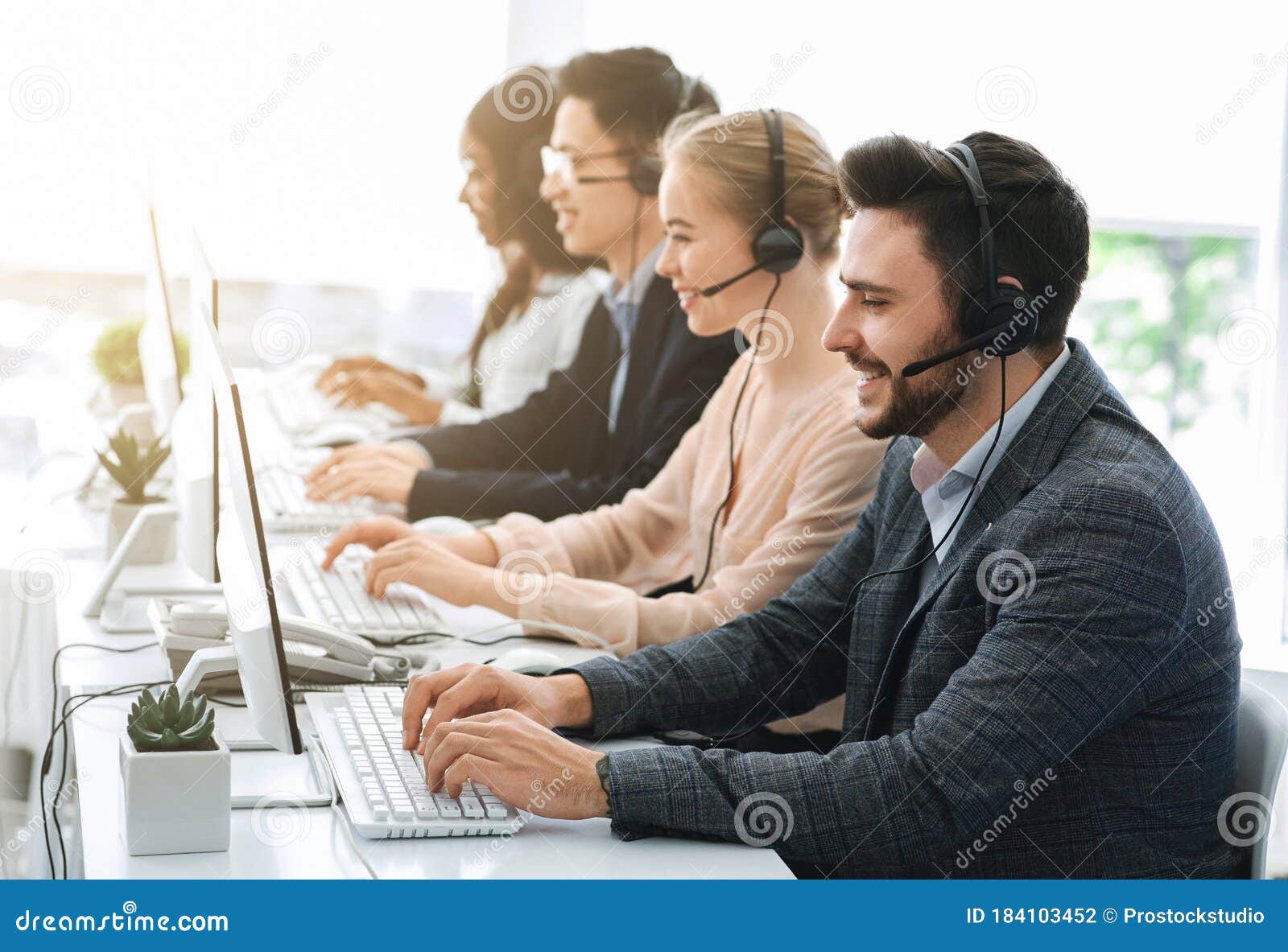 Telemarketing or Hotline Operators Working with Computers at Light ...