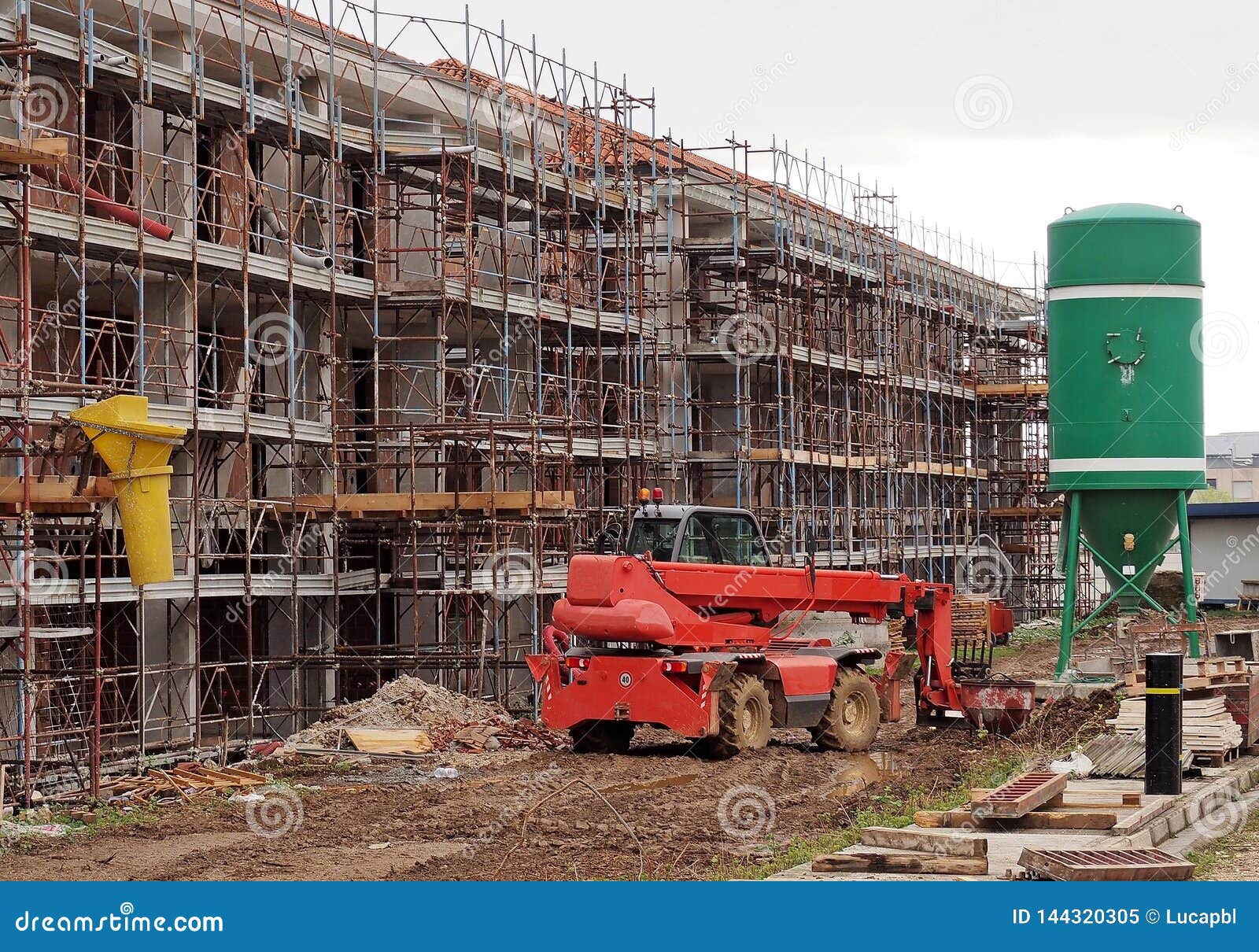 Telescopic Handler between a Building Under Construction Covered with ...