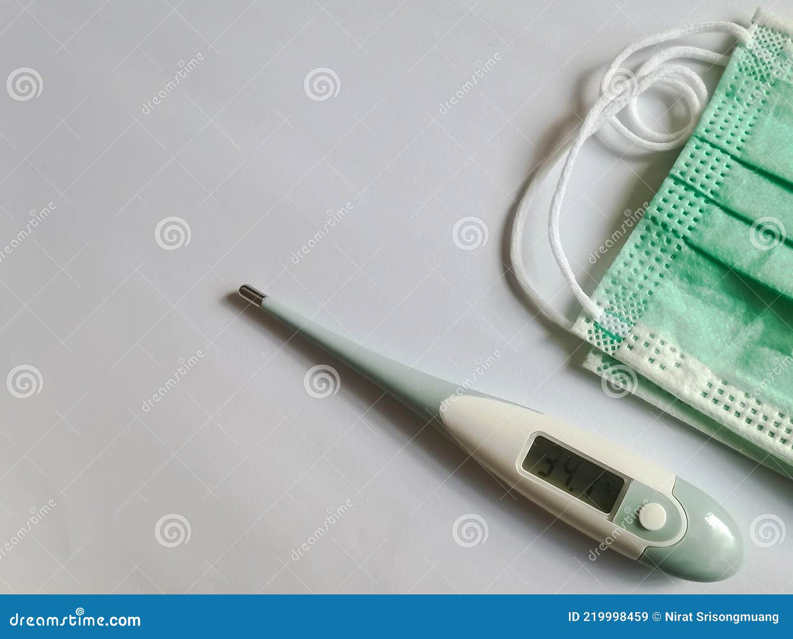 Temperature Meter with a Sanitary Mask on a White Background Stock ...