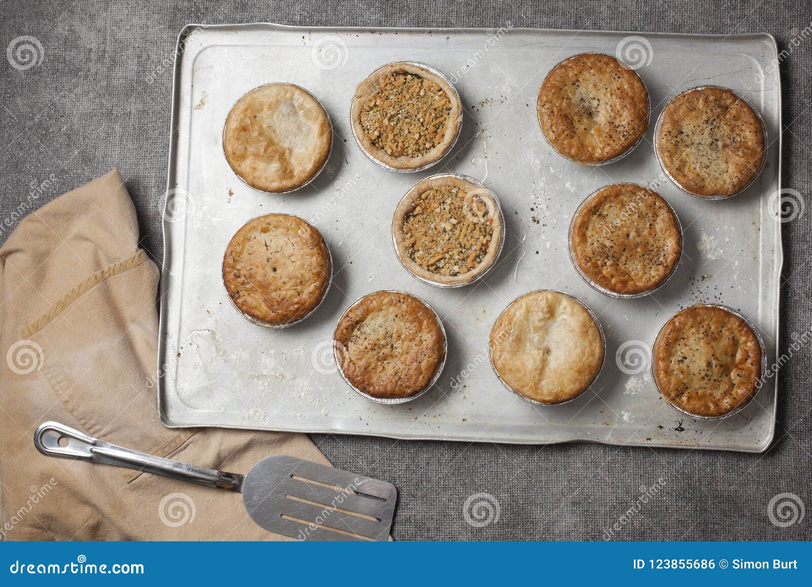 Ten pies on a baking tray stock photo. Image of spatula - 123855686