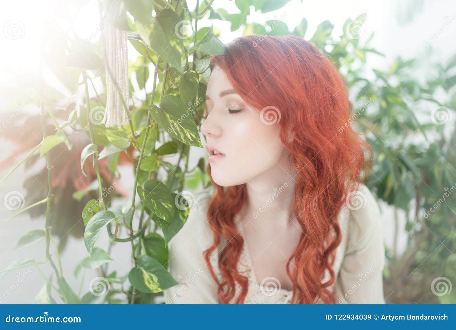 Tender Portrait Of A Young Beautiful Dreamy Redhead Woman Among Foliage