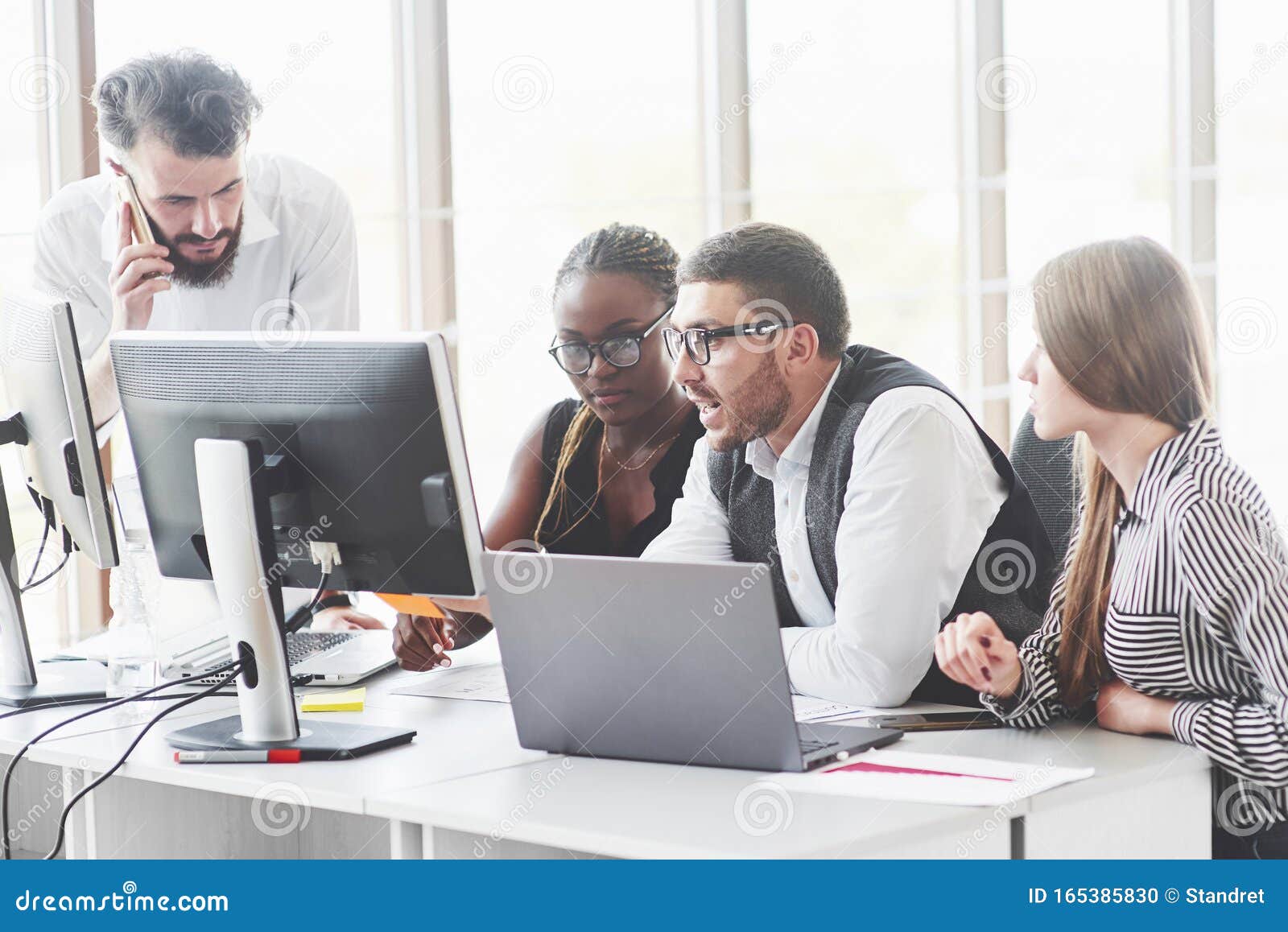 Tense Work of Four Employees Sitting in the Front of Monitors in the ...