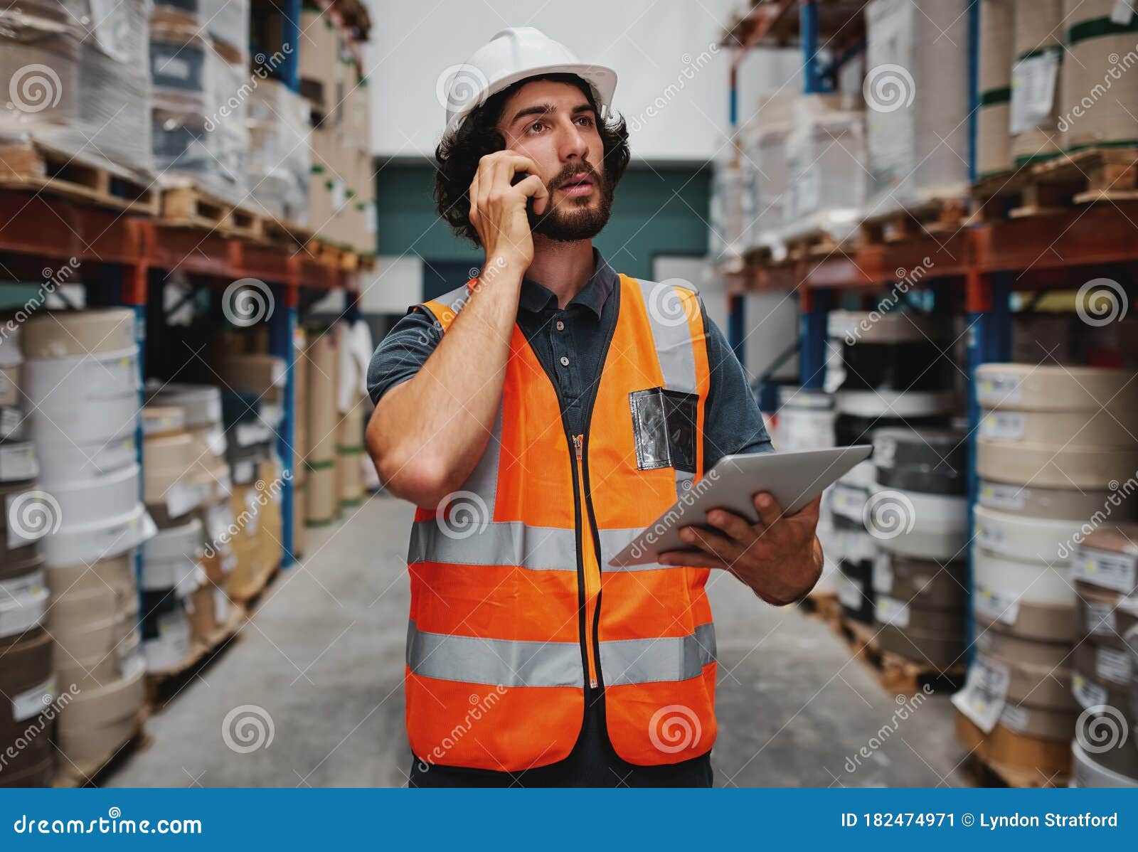 Tensed Warehouse Manager Holding Digital Tablet while Talking on Mobile ...