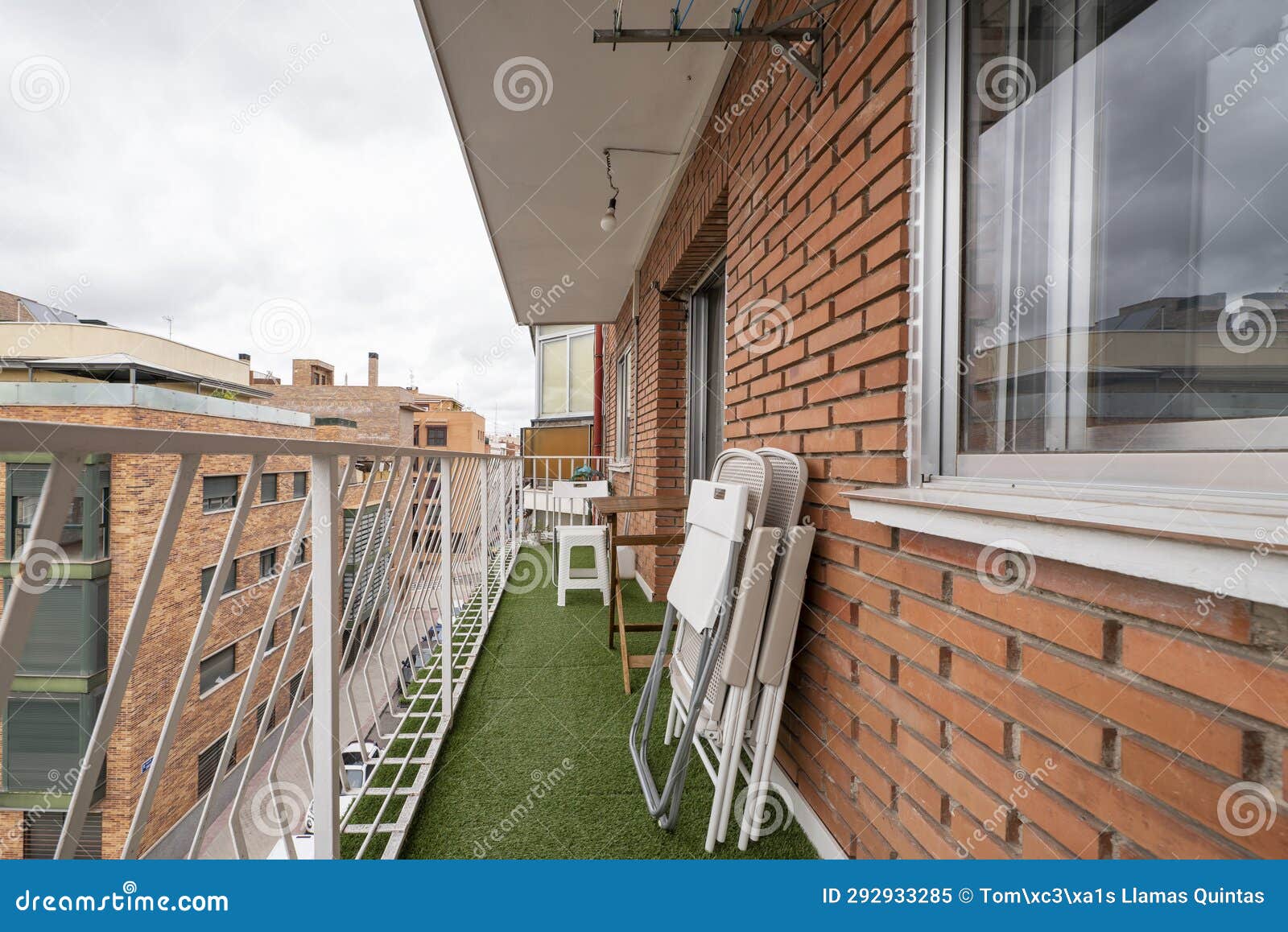 A Terrace with Artificial Grass Floor with White Railing and Folding ...