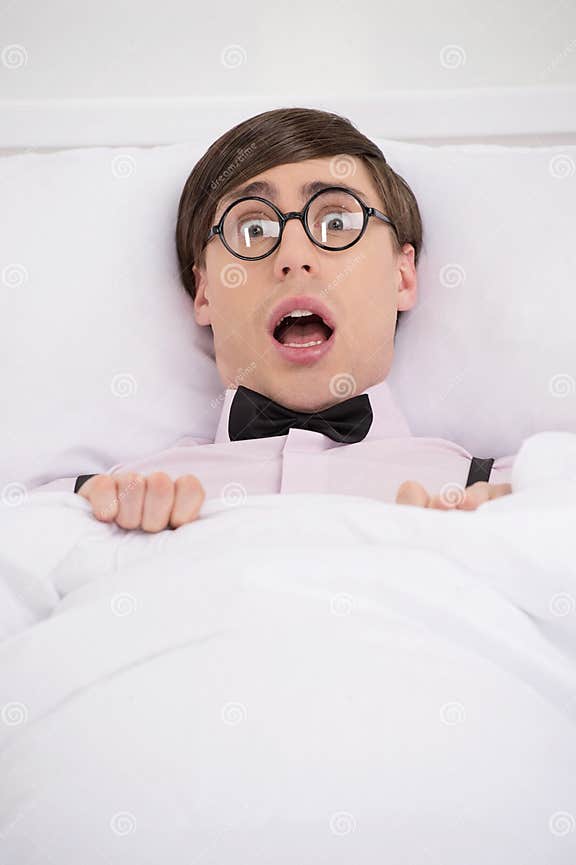 Terrified Nerd. Scared Nerd Lying on the Bed and Looking at Came Stock ...