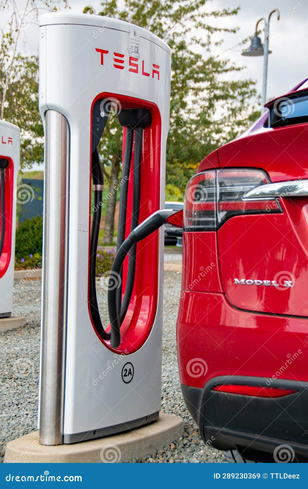 Tesla Charging Point in Sharp Focus with a Softly Focused Tesla Car ...