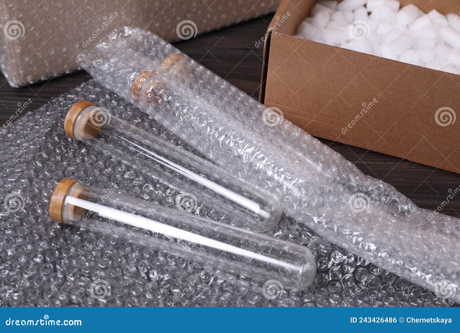 Test Tubes with Bubble Wrap and Cardboard Box on Table, Closeup Stock ...