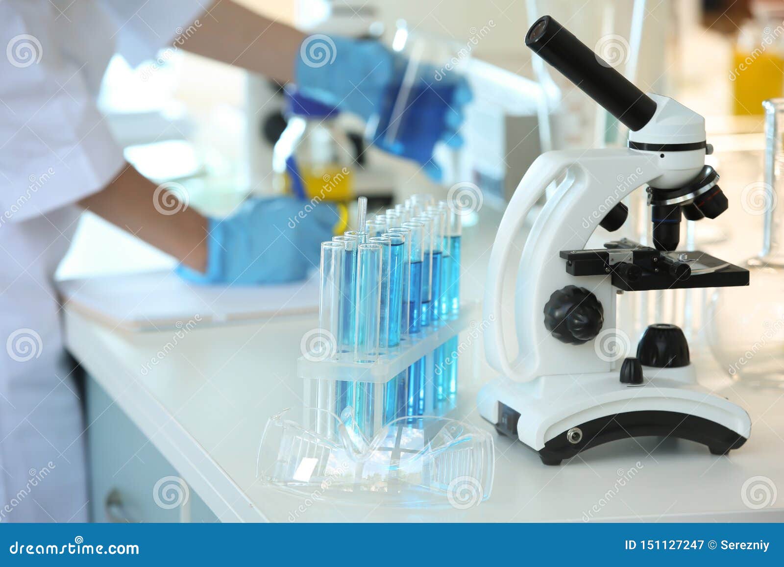Test Tubes with Samples and Modern Microscope on Table in Laboratory ...