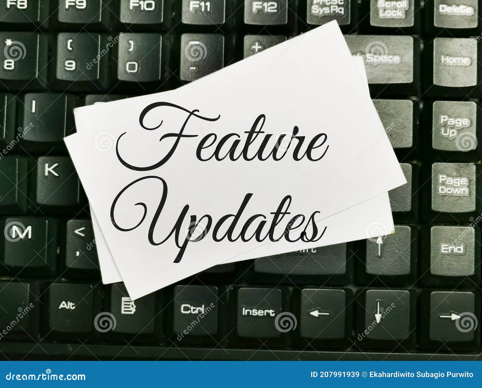 Text FEATURE UPDATES Written on White Paper Note on Computer Keyboard ...