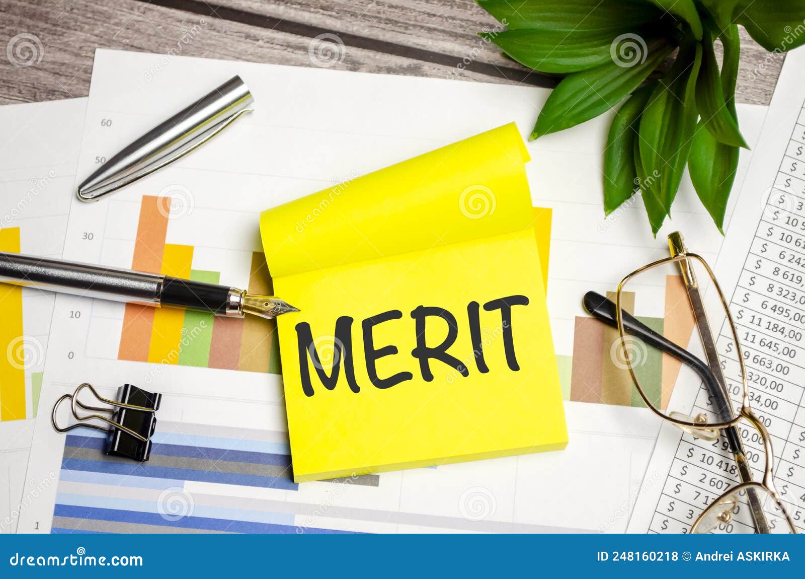 Text MERIT on Sticker with Charts, Glasses and Pen Stock Photo - Image ...