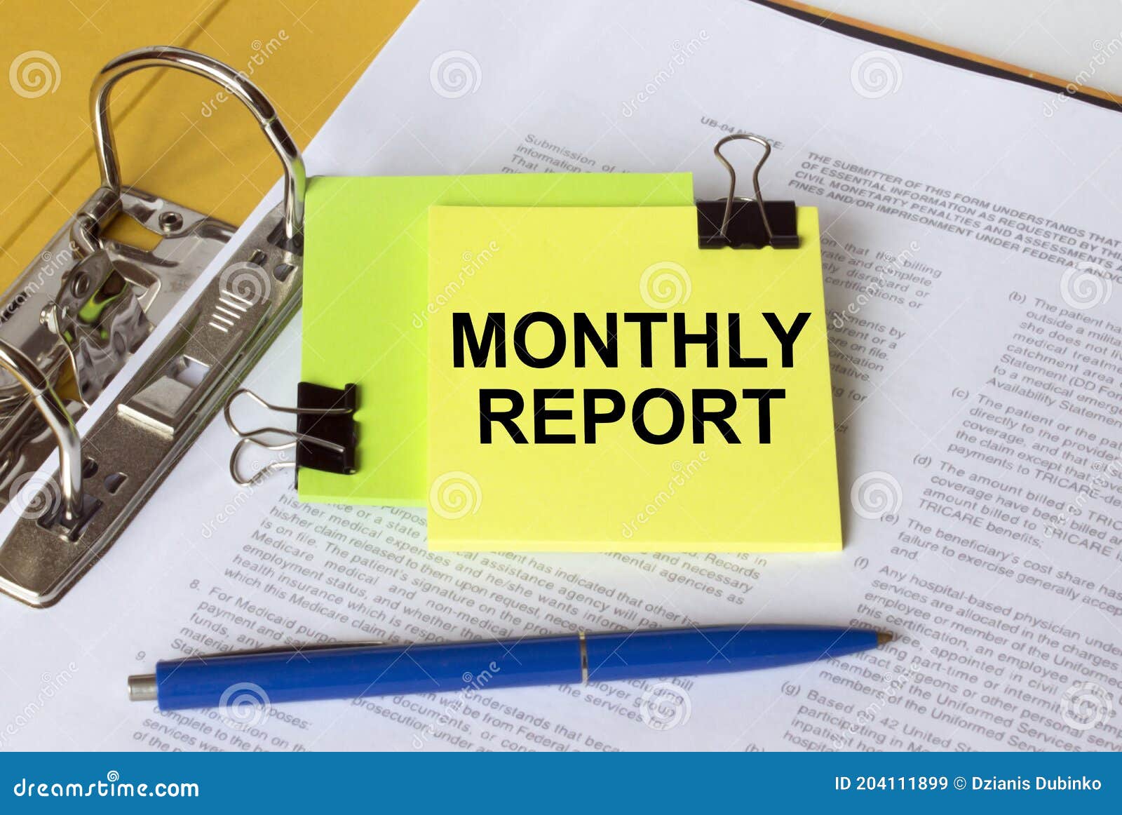 Text Monthly Report on a Yellow Sticker that is in a Folder with ...