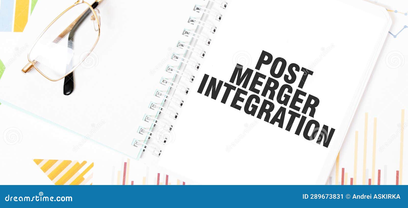 Text POST MERGER INTEGRATION on White Notepad, Glasses, Graphs and ...