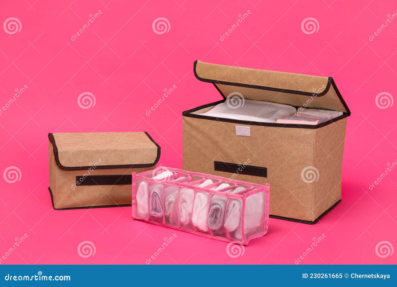 Textile Storage Cases and Organizer with Folded Clothes on Pink ...