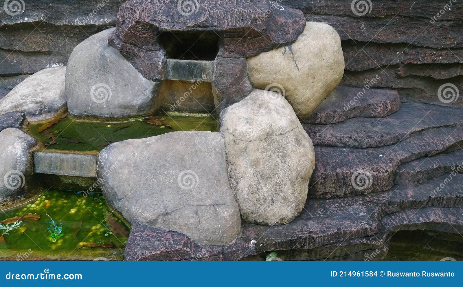 Rocks in the pond stock photo. Image of backyard, cave - 214961584