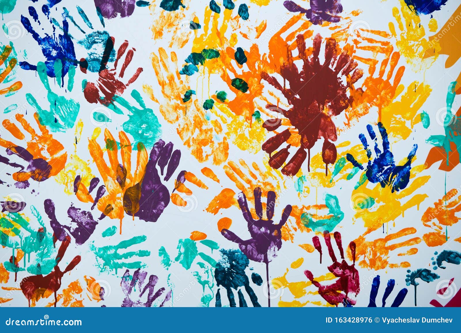 Multi-colored Prints of Hands Smeared with Paint on a White Wall Stock ...