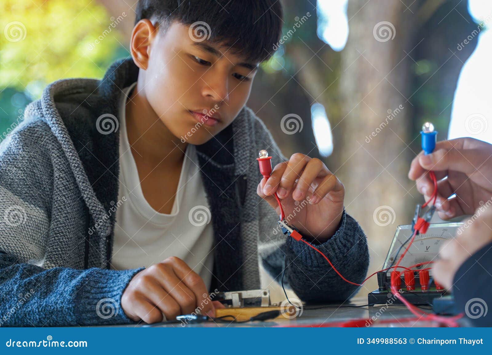 Thai Boy Performs an Outdoor Science Experiment on Connecting a Simple ...